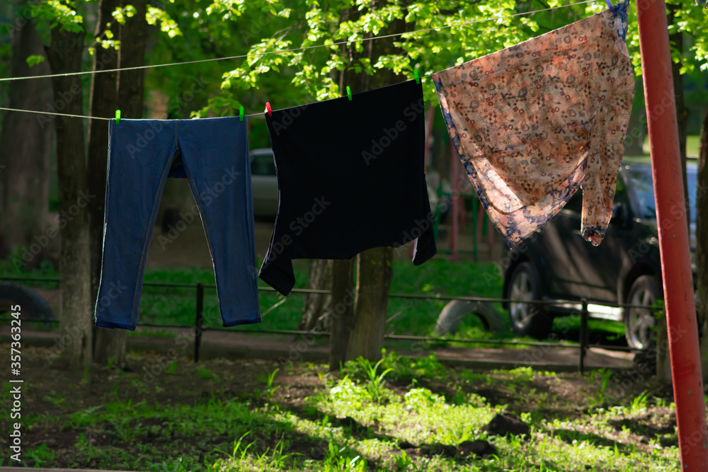 Clothes after washing hang on a rope in the yard and dry naturally in ...