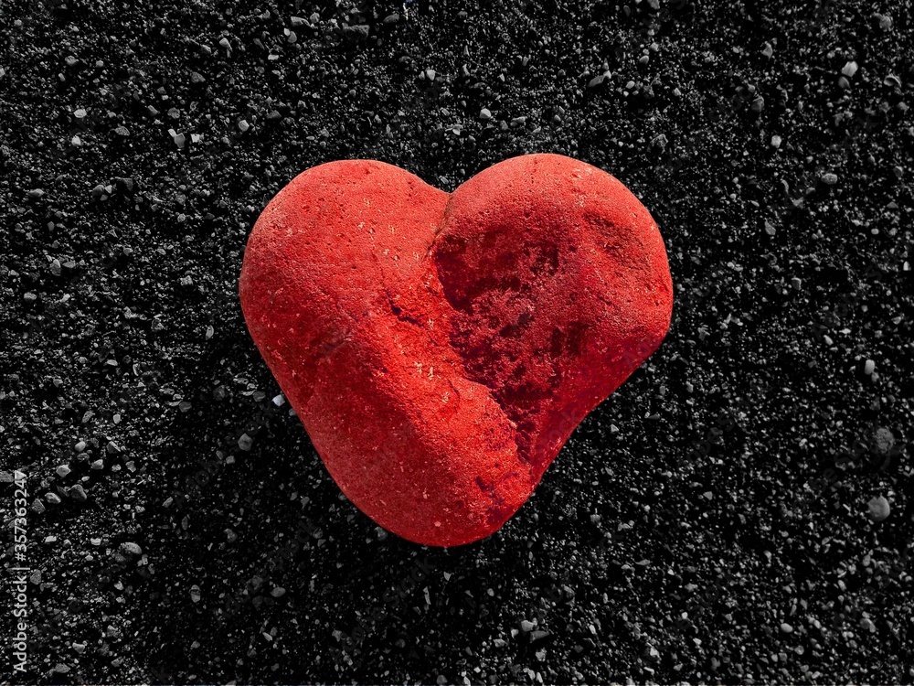 Zdjęcie Stock: Red heart stone in love shape on black rock background. Big red stone heart shape ...