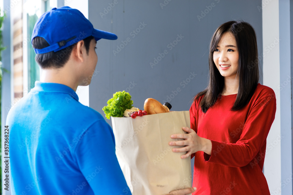 Asian delivery man delivering food, fruit, juice and vegetable to ...