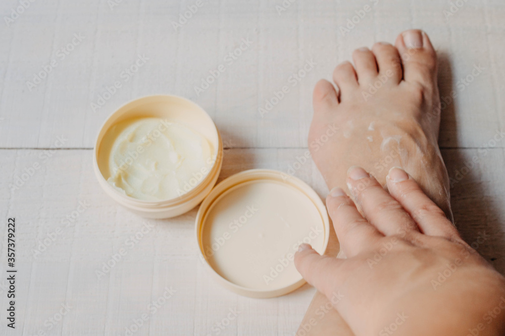 Foot and foot skin care. Body and foot cream is applied by a woman's ...