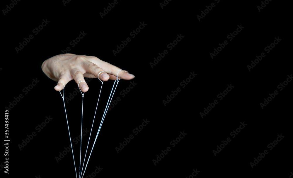 The female hand controls the doll with the fingers, using white threads ...