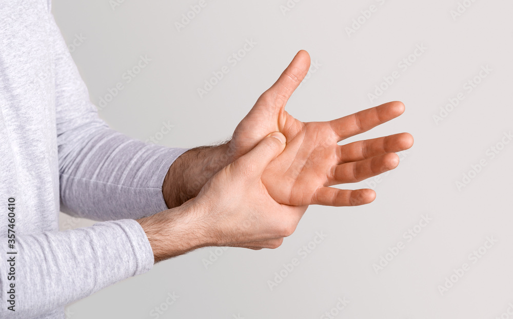 Body ache. Man presses his hand to hand in pain due to arthritis or ...