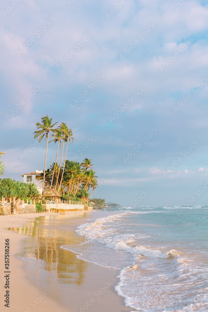 Tropical beach in soft evening sunlight. Sandy shore, palm trees and ...