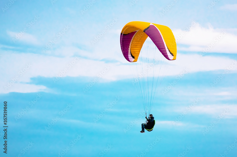 Paraglider in the sky. Bright paraplan flying in blue sky, space for ...