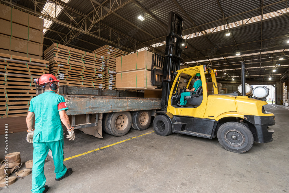 wood pallet forklift driving at a factory floor inside a shed loading a ...
