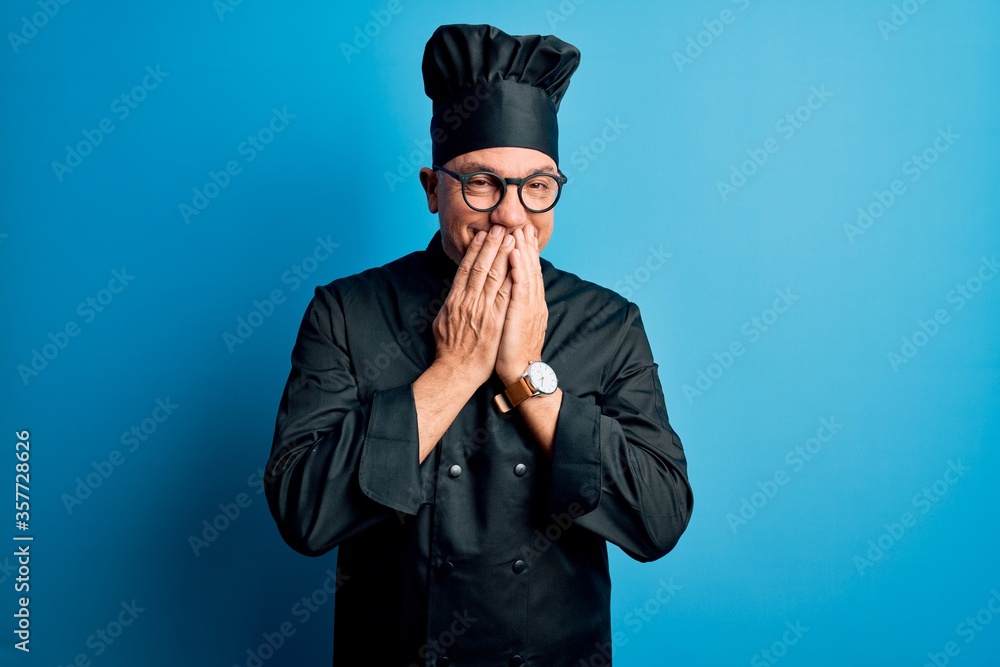 Middle age handsome grey-haired chef man wearing cooker uniform and hat ...
