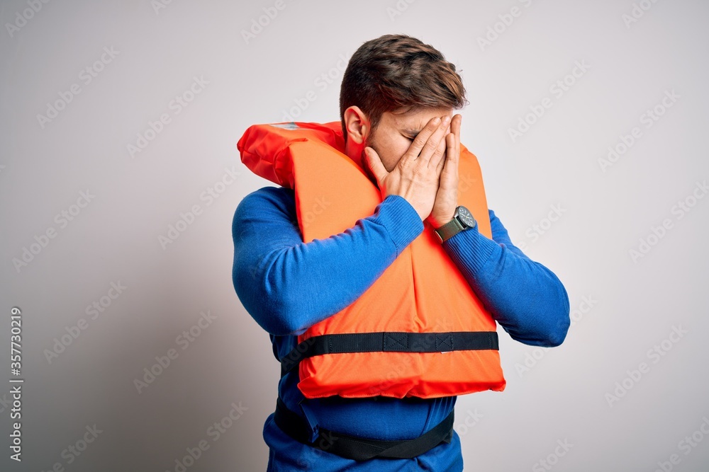 Young blond tourist man with beard and blue eyes wearing lifejacket ...