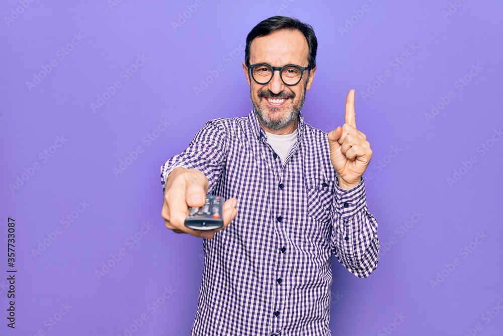 Middle age man changing tv channel using television remote control over ...