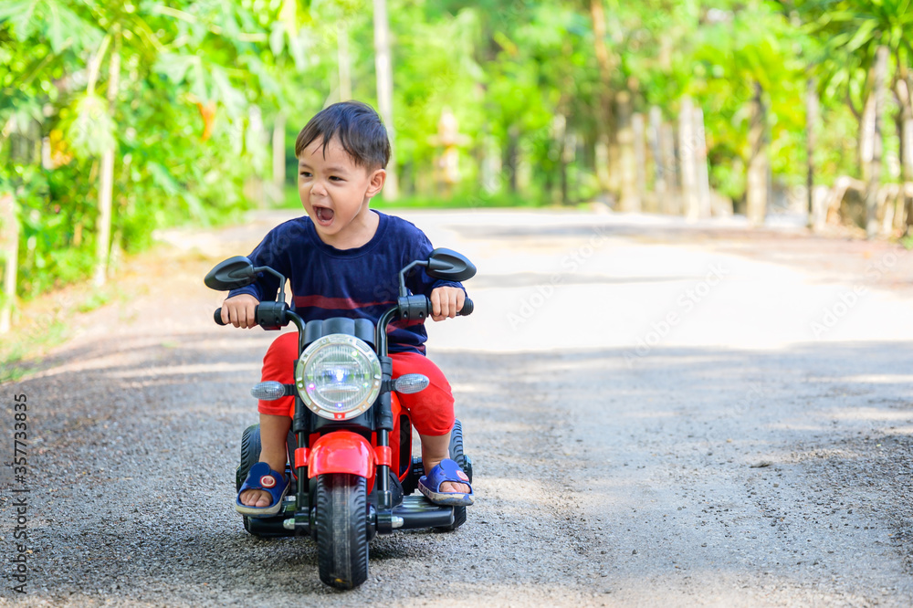 Cute little biker on road with motorcycle. Young boy on toy motorcycle ...
