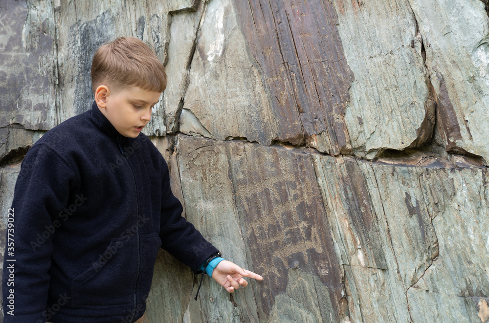 Ancient cave paintings and little boy. Bronze Age culture dated to the ...