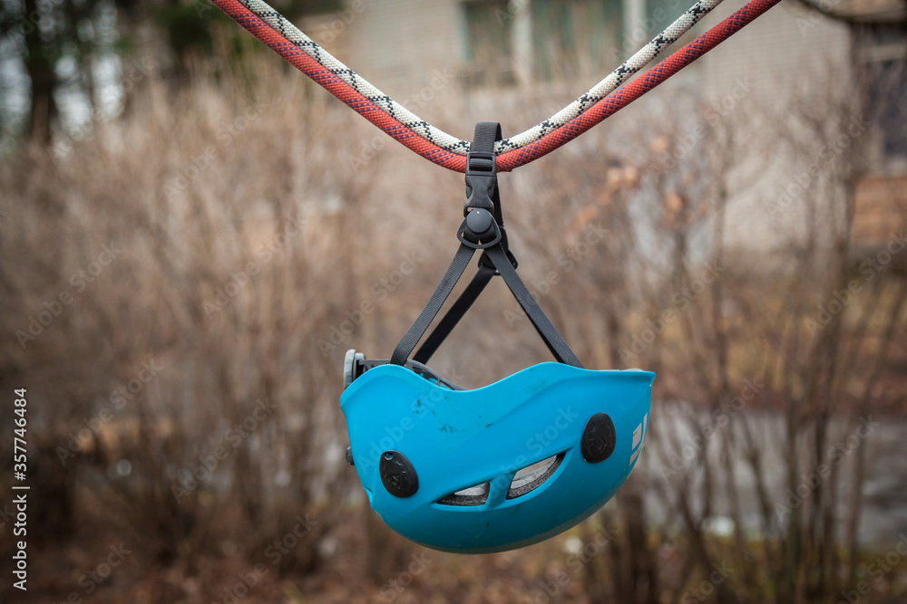 Blue helmet on a climbing rope. Climbing equipment, safety ropes and ...