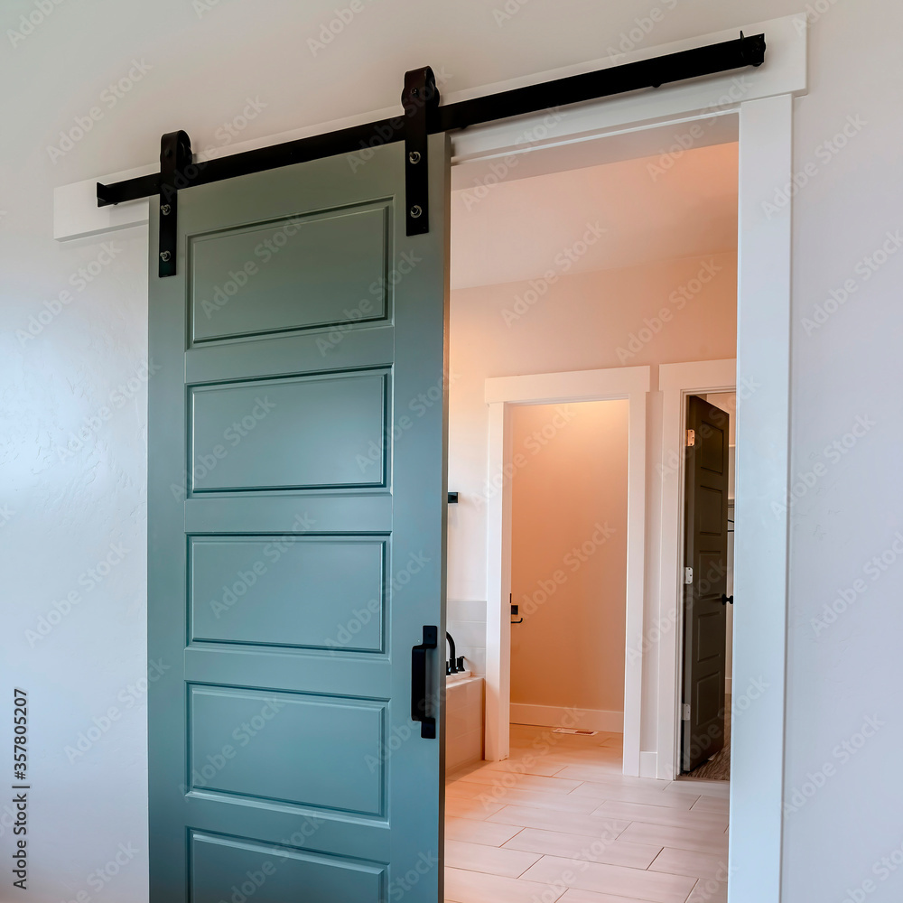 Square frame Sliding gray wooden panel door that leads to the bathroom ...