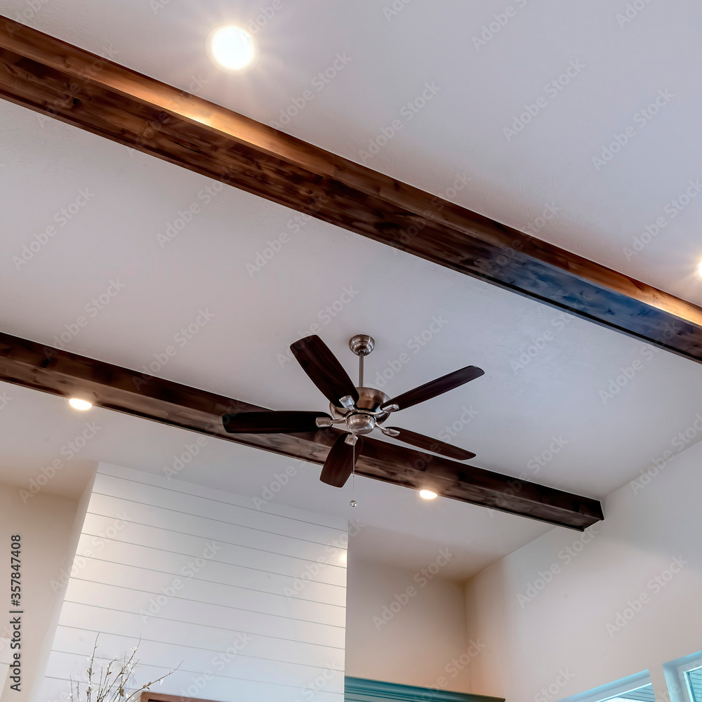 Square frame Ceiling fan with lights flanked by decorative wood beams ...
