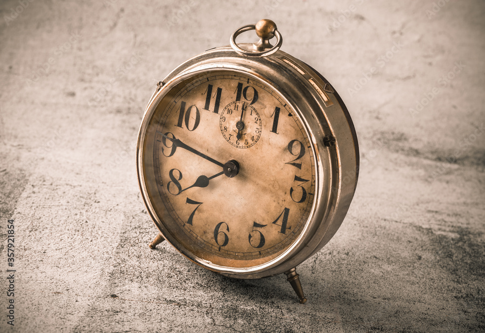 Old rustic metal clock front view on rustic concrete background studio ...