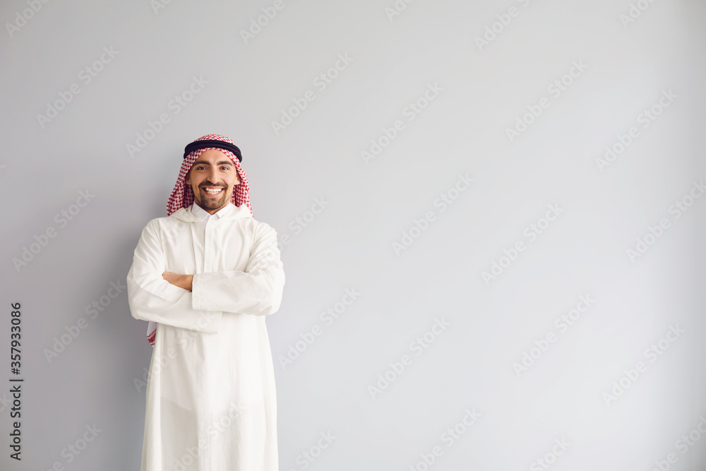 Arab male businessman smiling portrait standing on a gray background ...