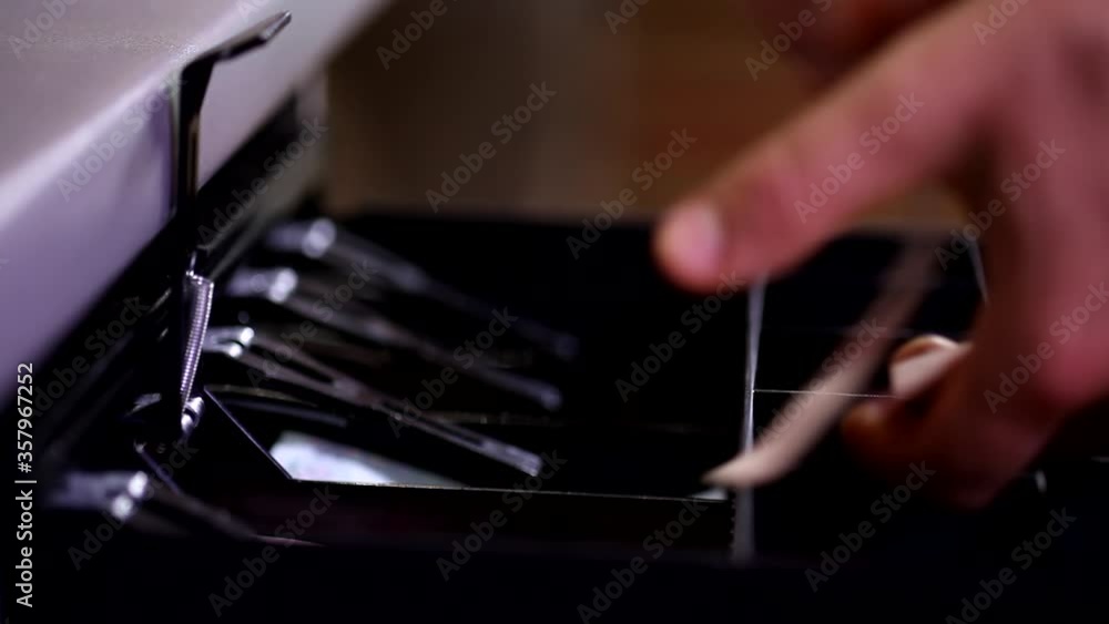 Close up shot of man cashier hand opening cash register drawer with key ...
