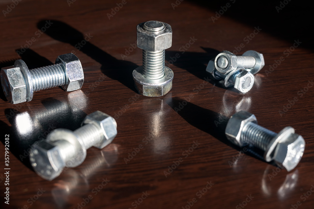 A lot of bolts and nuts on the table. A bolt is a form of threaded ...