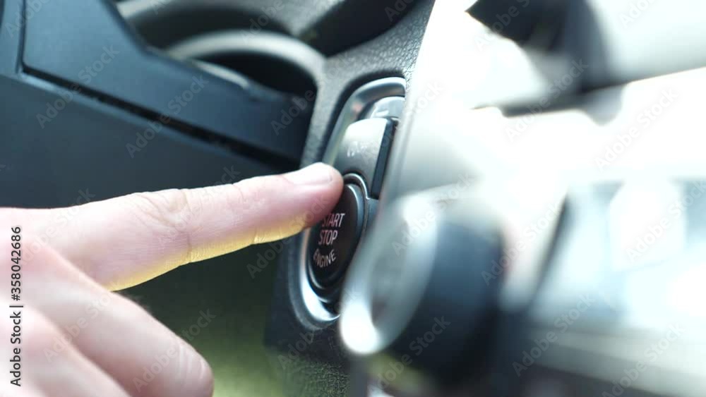 Close up male hand starting car with button. Man hand pushing start ...