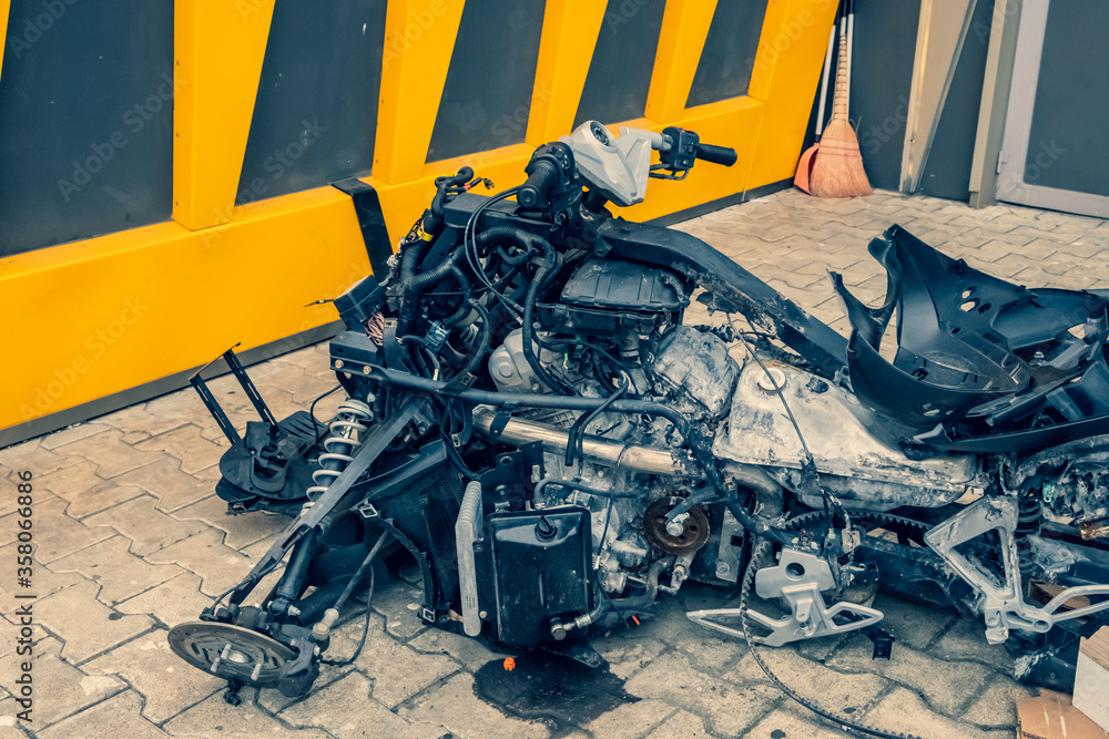 Foto de Vehicle, tricycle, after an accident. A burned motorcycle near ...