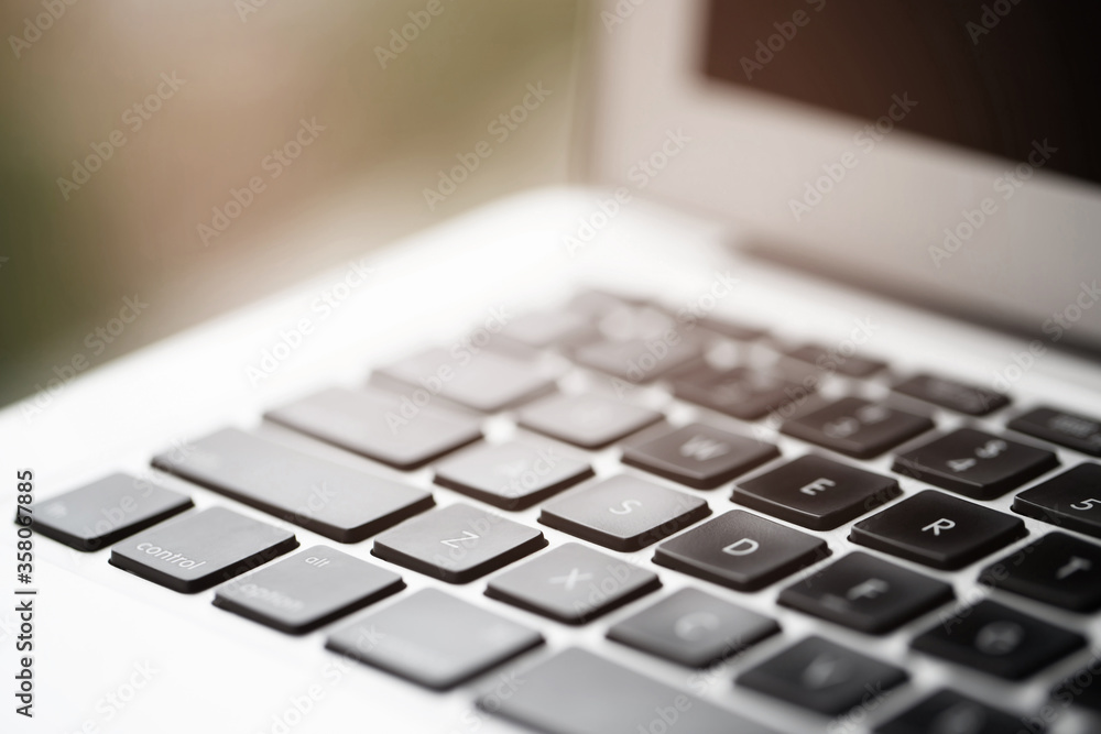 A modern laptop, stylish computer keyboard the area of the work desk in ...