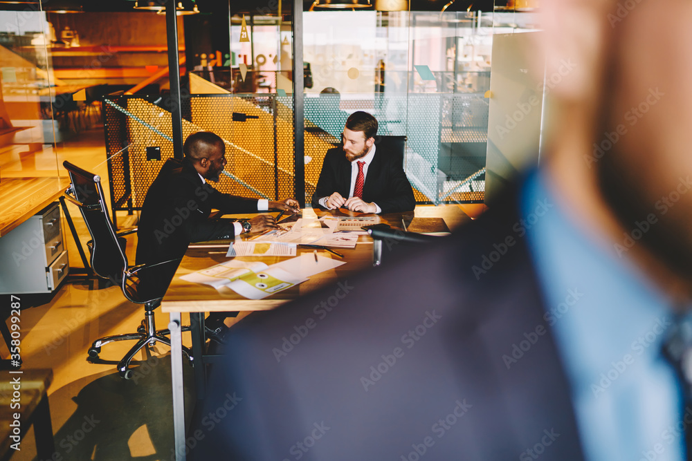 Cropped image of male colleagues talking during meeting on background ...