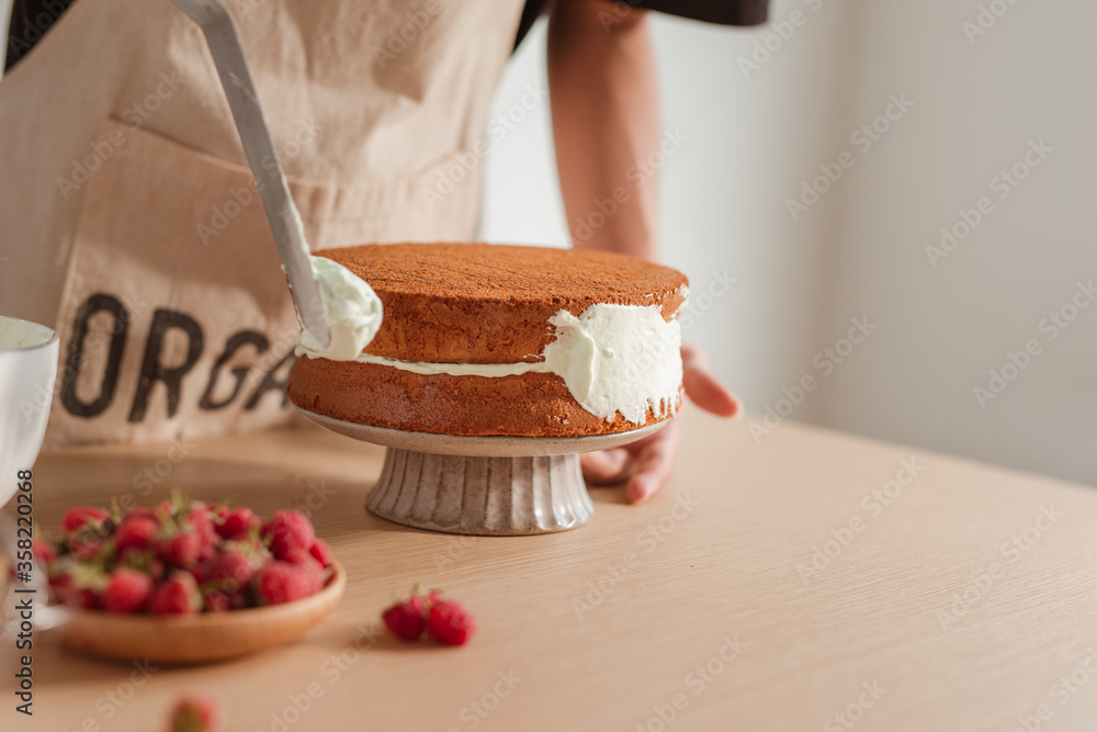 Pastry chef puts the cream on the Cakes. Process cooking sponge cake ...