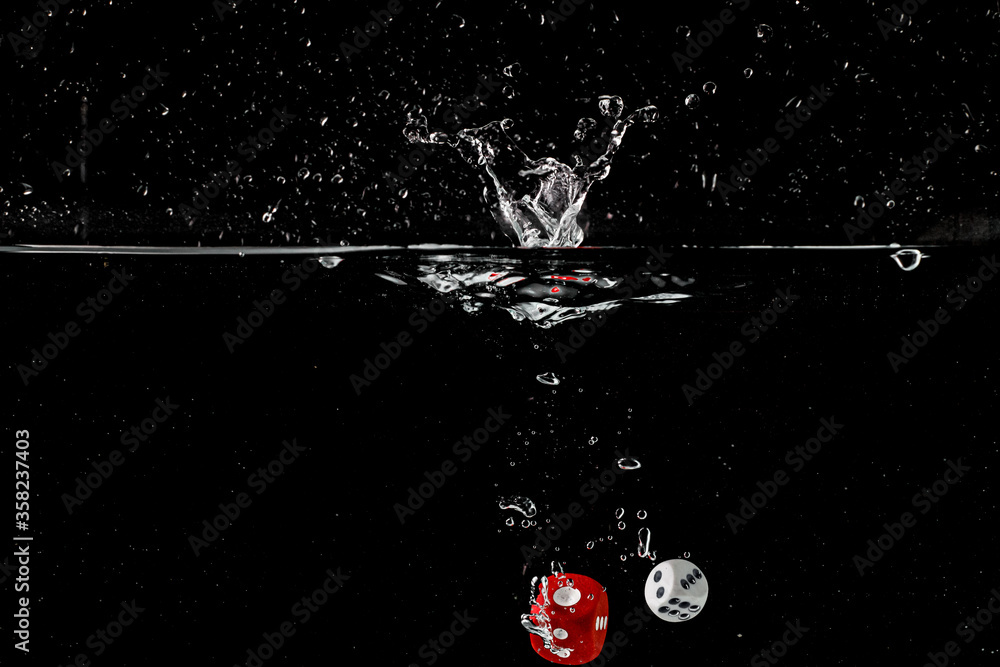 Ludo dice in water splash on black background with lots of air bubbles ...