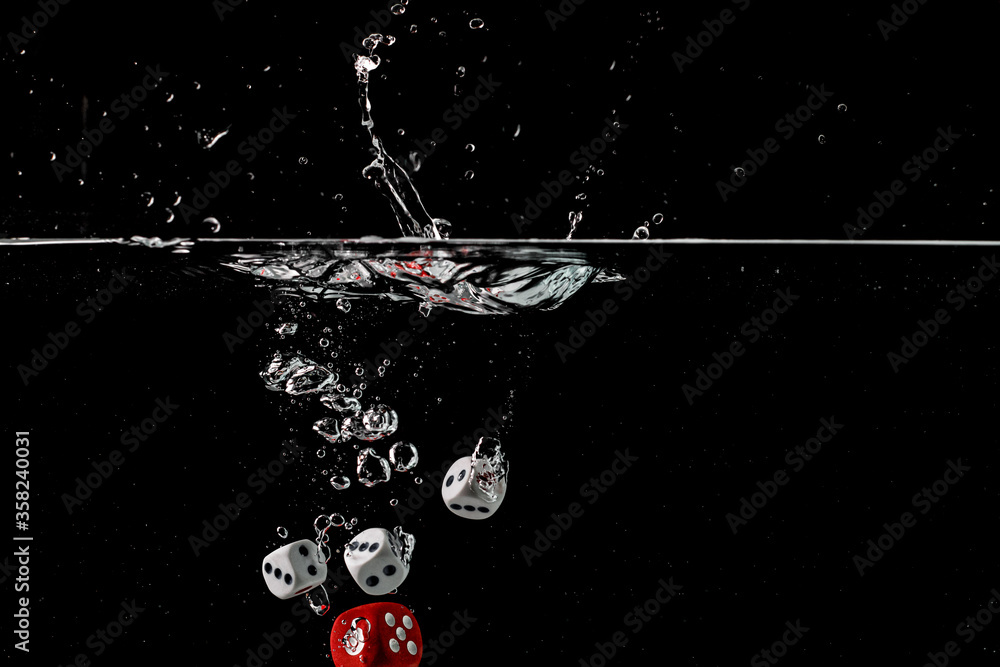 Ludo dice in water splash on black background with lots of air bubbles ...