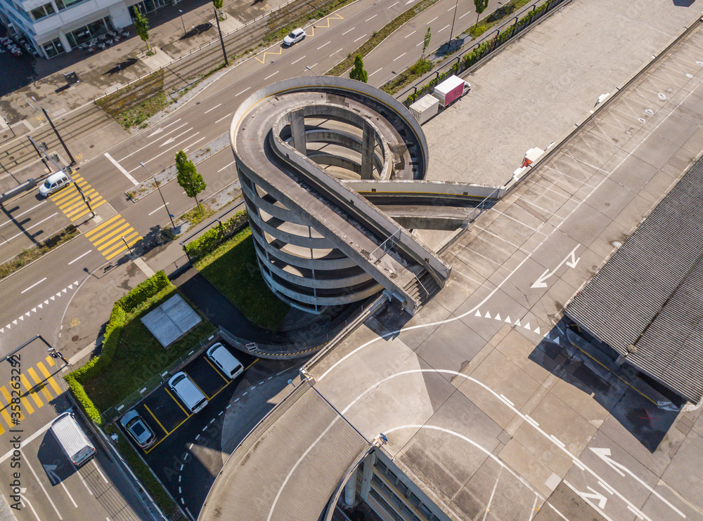 Aerial view of rooftop parking ramp. Spiral ramp leading cars to ...