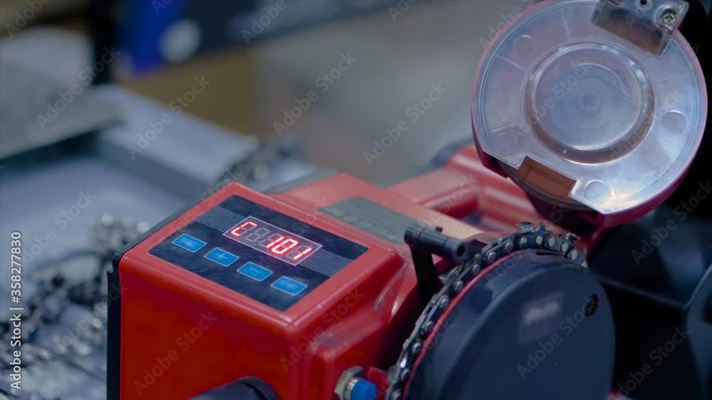 Super slow motion: automatic red saw chain sharpening machine during ...