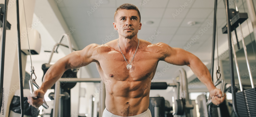 Young handsome sportsman bodybuilder weightlifter with an ideal body ...