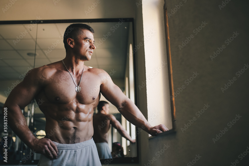 Handsome power athletic man on diet training pumping up muscles with ...