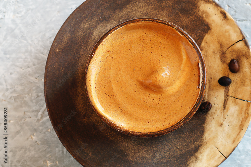 Dalgon coffee in a ceramic Cup on a plate with coffee beans. Indian ...