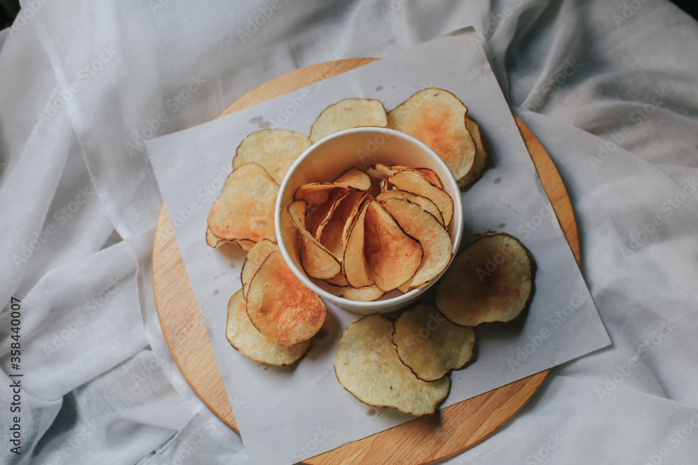Fresh homemade deep fried crispy potato chips in white box on a wooden ...