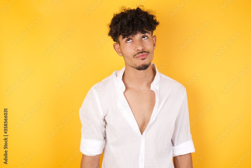 Gloomy, wondering young man face looking up lips together, being upset ...