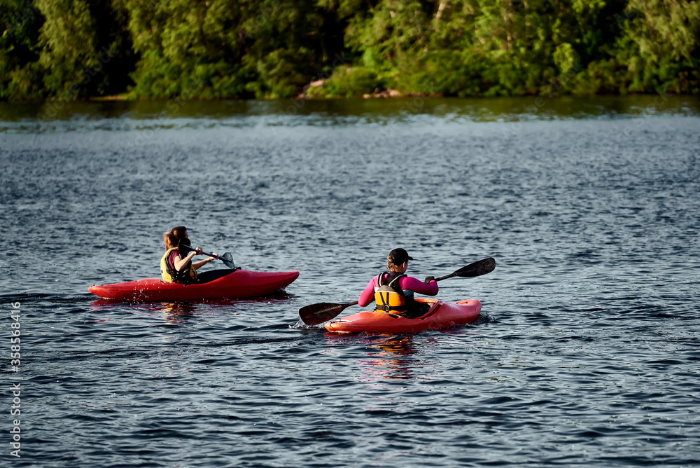 Two girls in a canoe-polo helmet rowing with weights and swimming on ...
