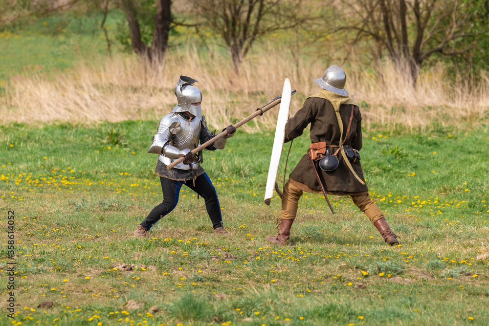 Knights in armor fight on the battlefield. Reconstruction of an ancient ...