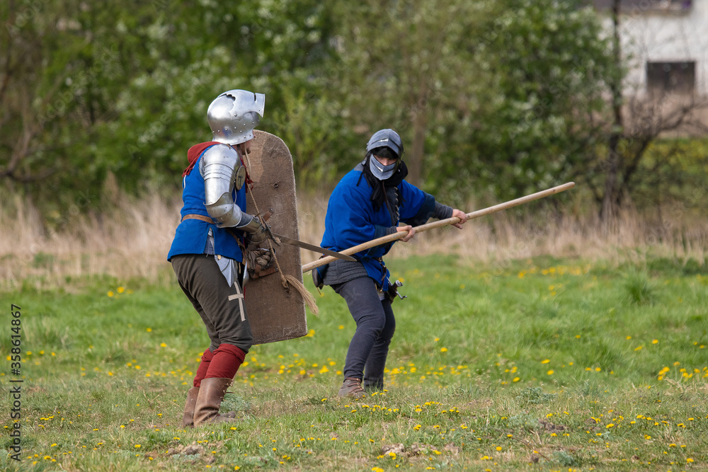 Knights in armor fight on the battlefield. Reconstruction of an ancient ...