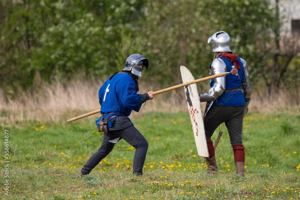 Knights in armor fight on the battlefield. Reconstruction of an ancient ...