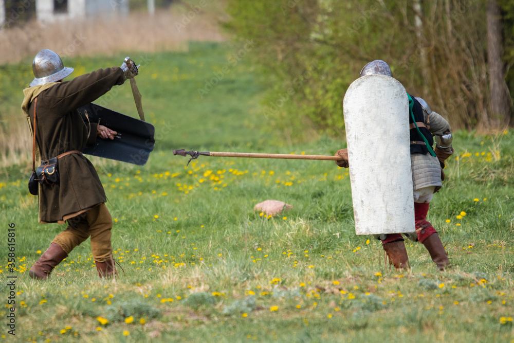 Knights in armor fight on the battlefield. Reconstruction of an ancient ...