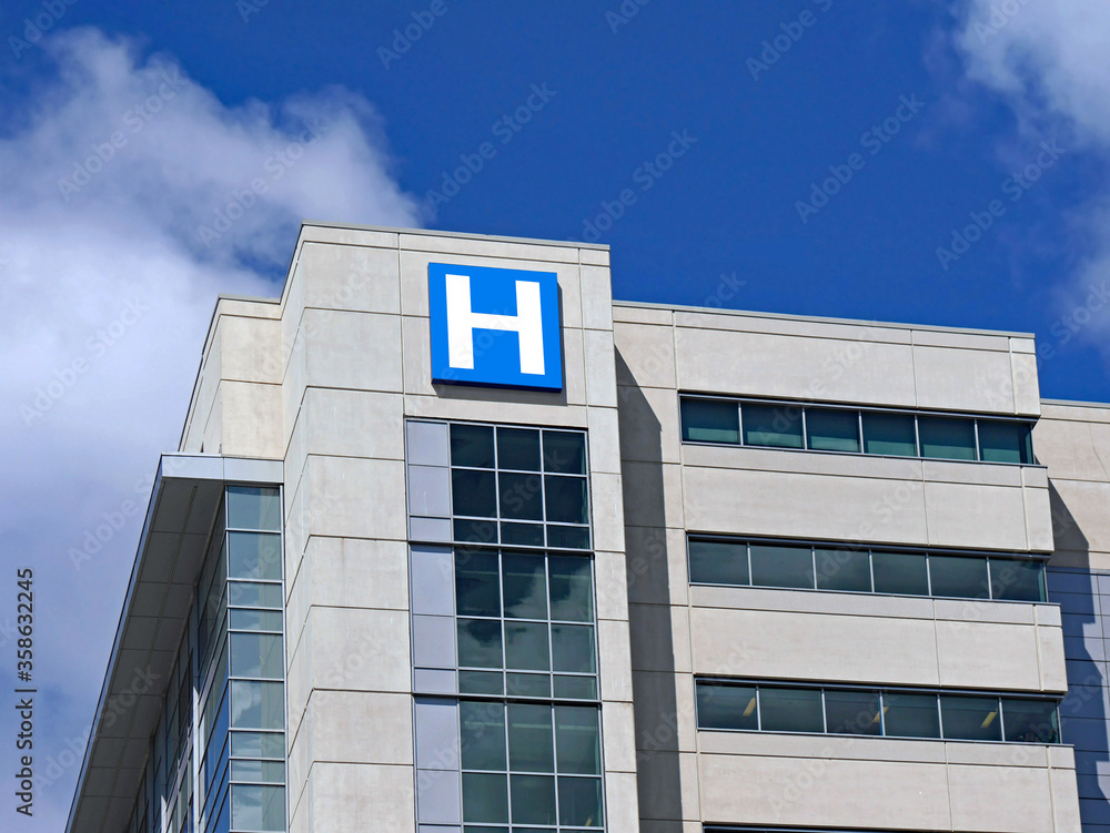 large modern building with blue letter H sign for hospital Stock Photo ...