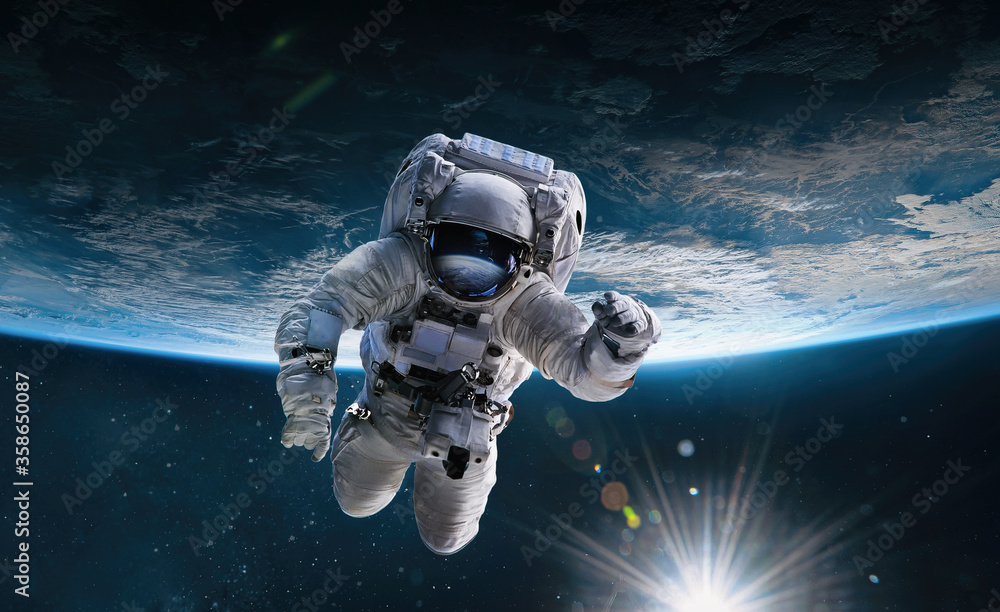 Astronaut in the outer space with Sun over the planet Earth. Abstract ...