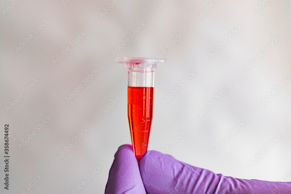 Red sample in a 1.5 ml microcentrifuge tube in gloved hand Stock Photo ...
