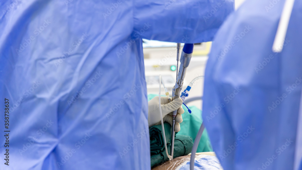 Surgeon in blue surgical gown uniform doing lumbar puncture before ...