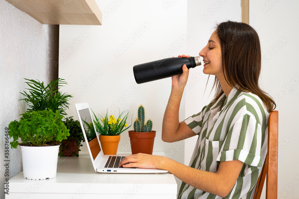 Office worker drinking water from a thermos in the office. Drinking ...