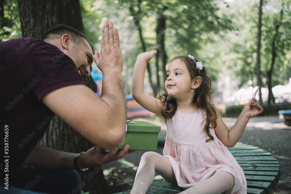 Dad and child giving high five outdoor. Daughter and her doing high ...