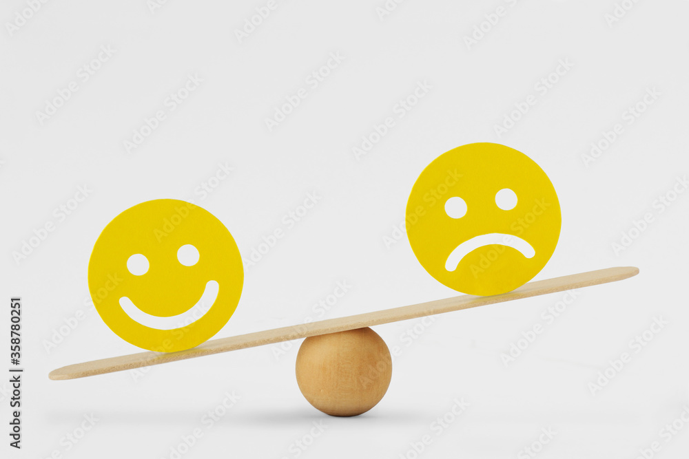 Smiley face and sad face on scale - Concept of happiness as predominant ...