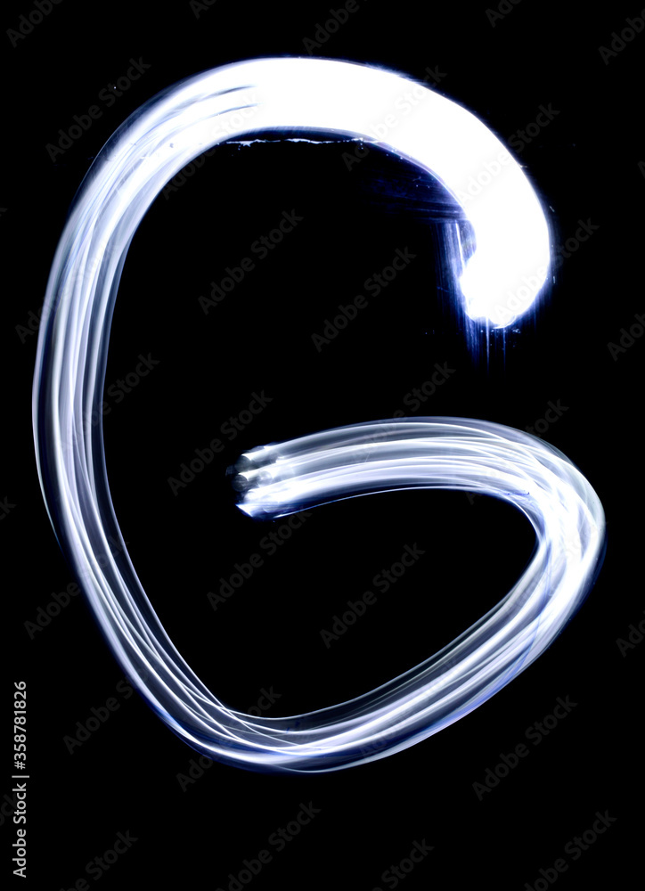 Handwrite letter G, made with light painting technic isolated on black ...