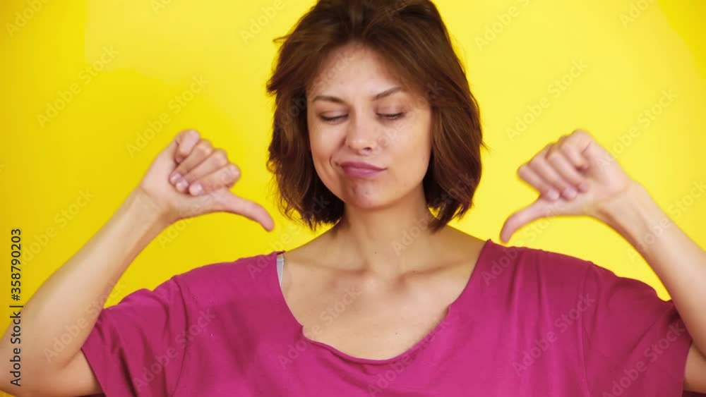 Pretty irritated woman standing on yellow studio background expressing ...