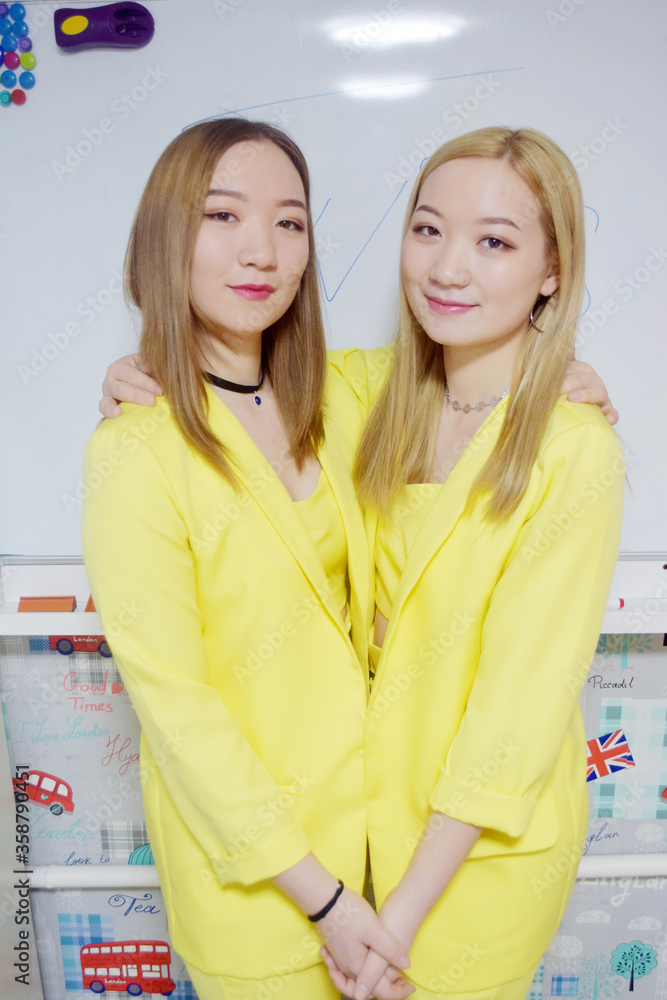 Asian twin sisters holding hands and hugging Stock Photo | Adobe Stock